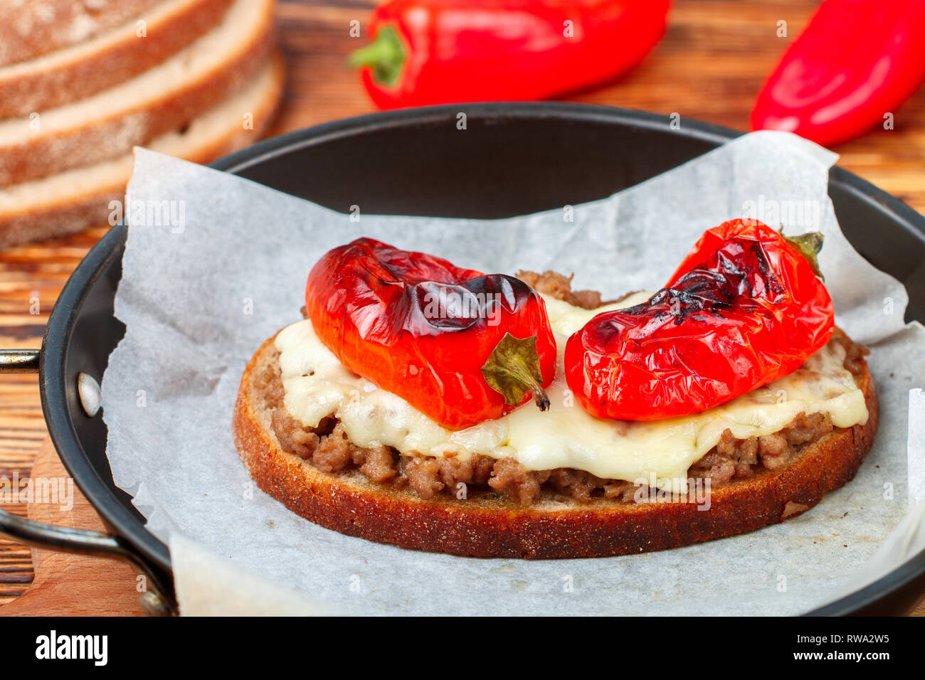 Baked bread toast with minced meat, cheese and red pepper. Delicious ...