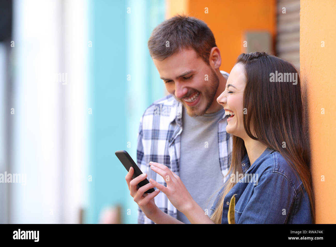 Happy Couple Laughing Loud Checking Smart Phone Online Content In A