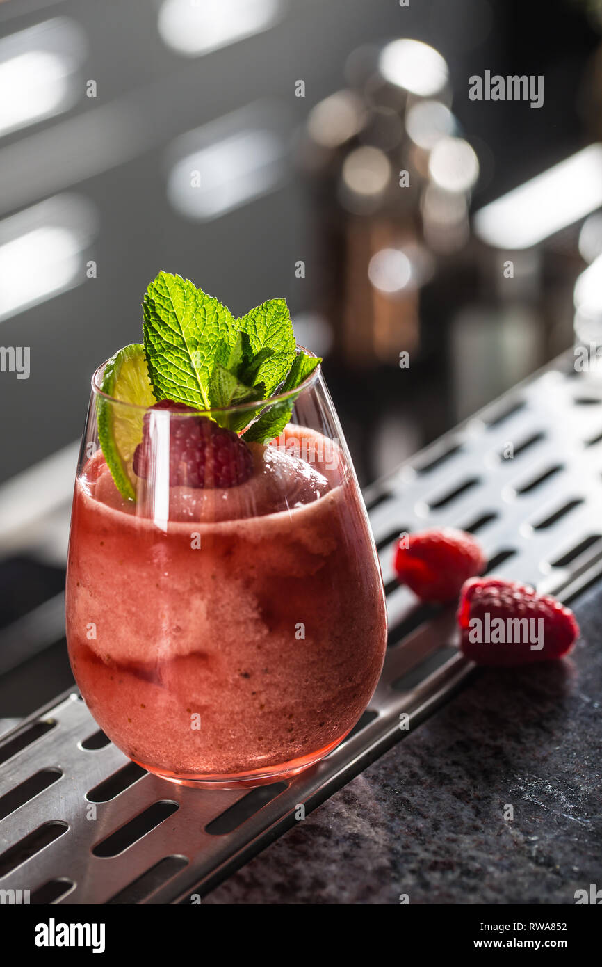 Cocktail drink frozen raspberries daiquiri at barcounter in night club ...