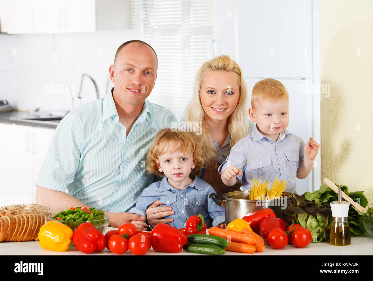 Positive family preparing lunch together Stock Photo - Alamy