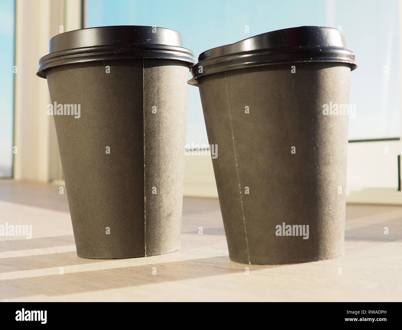 Cups of coffee different sizes on cafe table near window Stock Photo ...