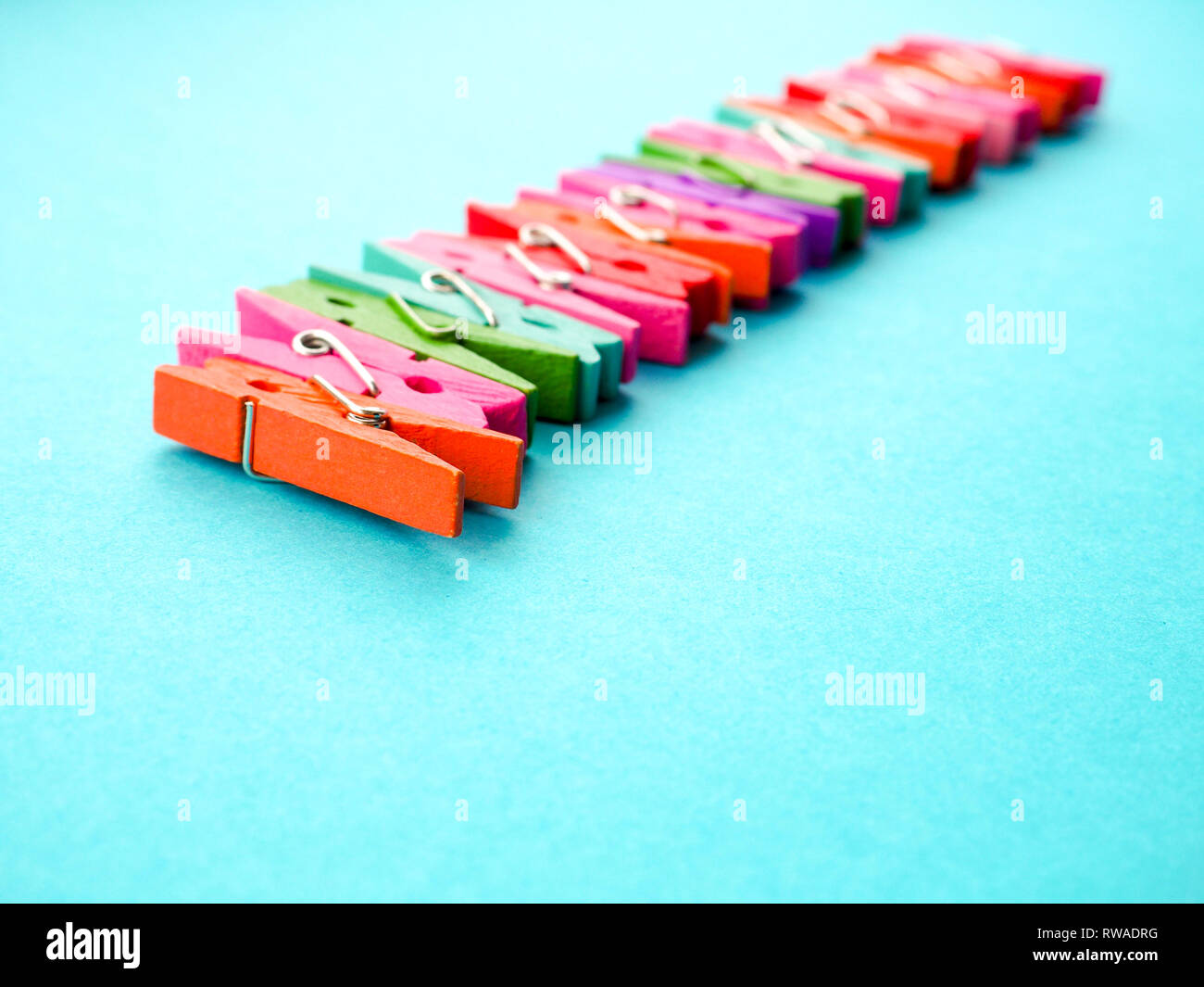 A lot of colored wooden clothespins with long shadows, isolated on a ...
