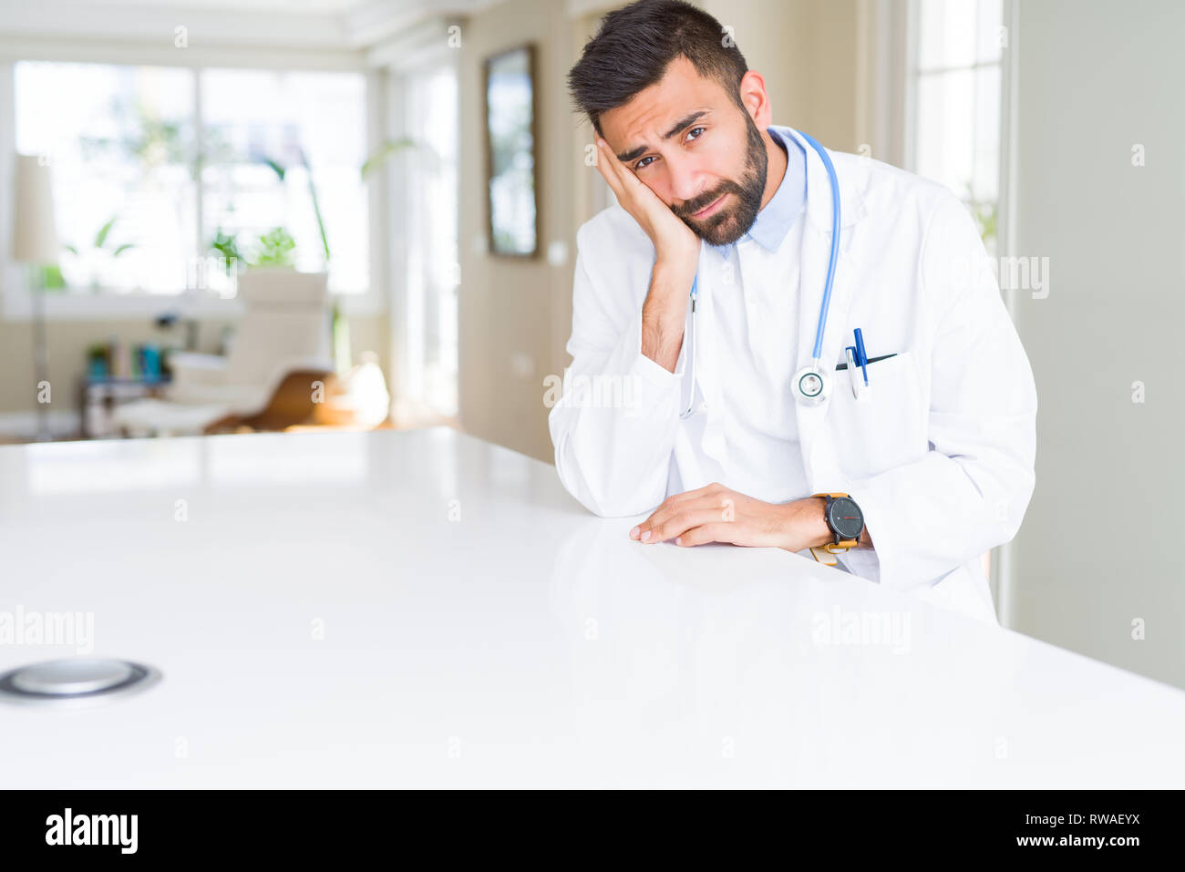 Handsome hispanic doctor man wearing stethoscope at the clinic thinking ...
