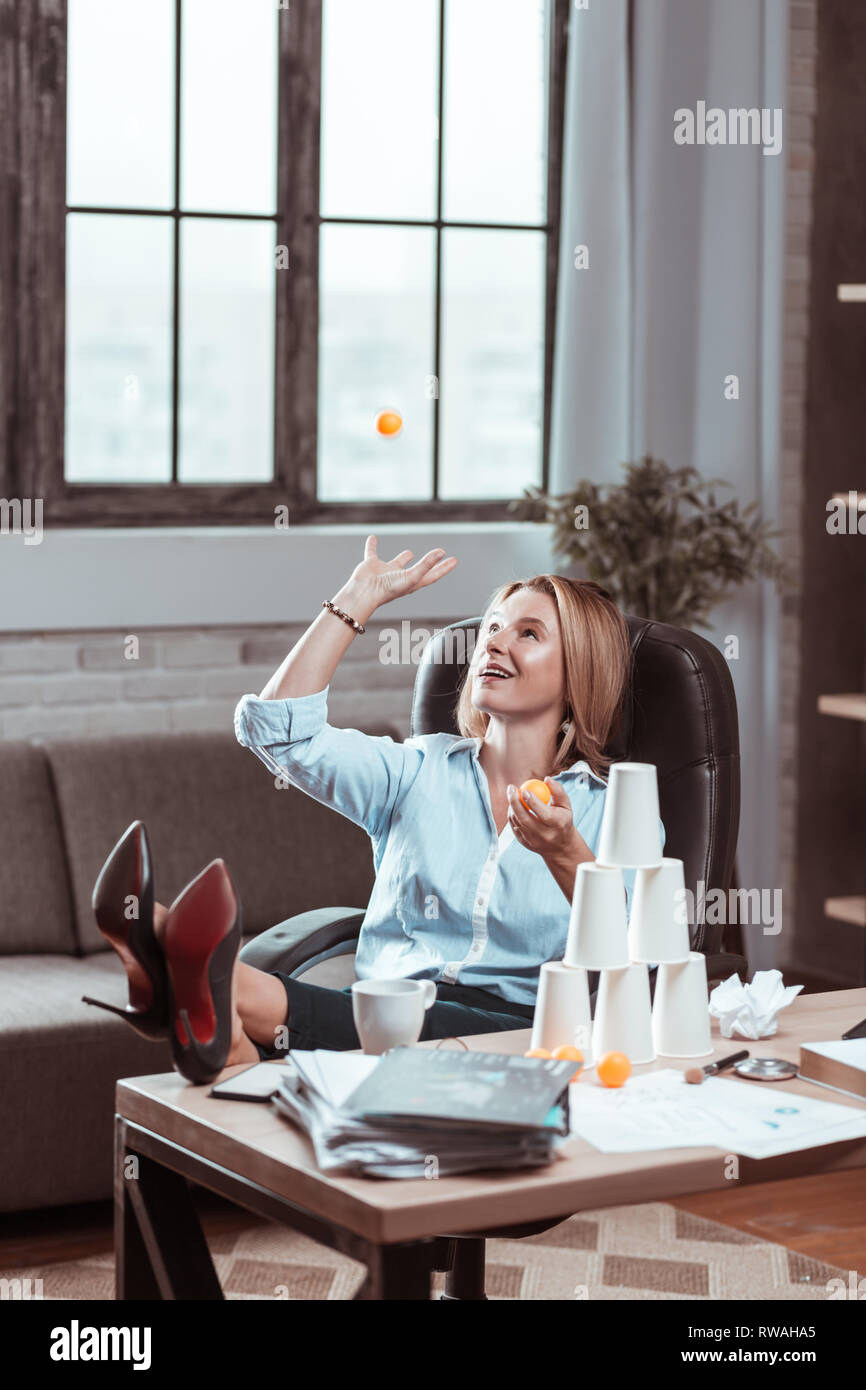Woman going crazy at work playing with tennis ball Stock Photo - Alamy