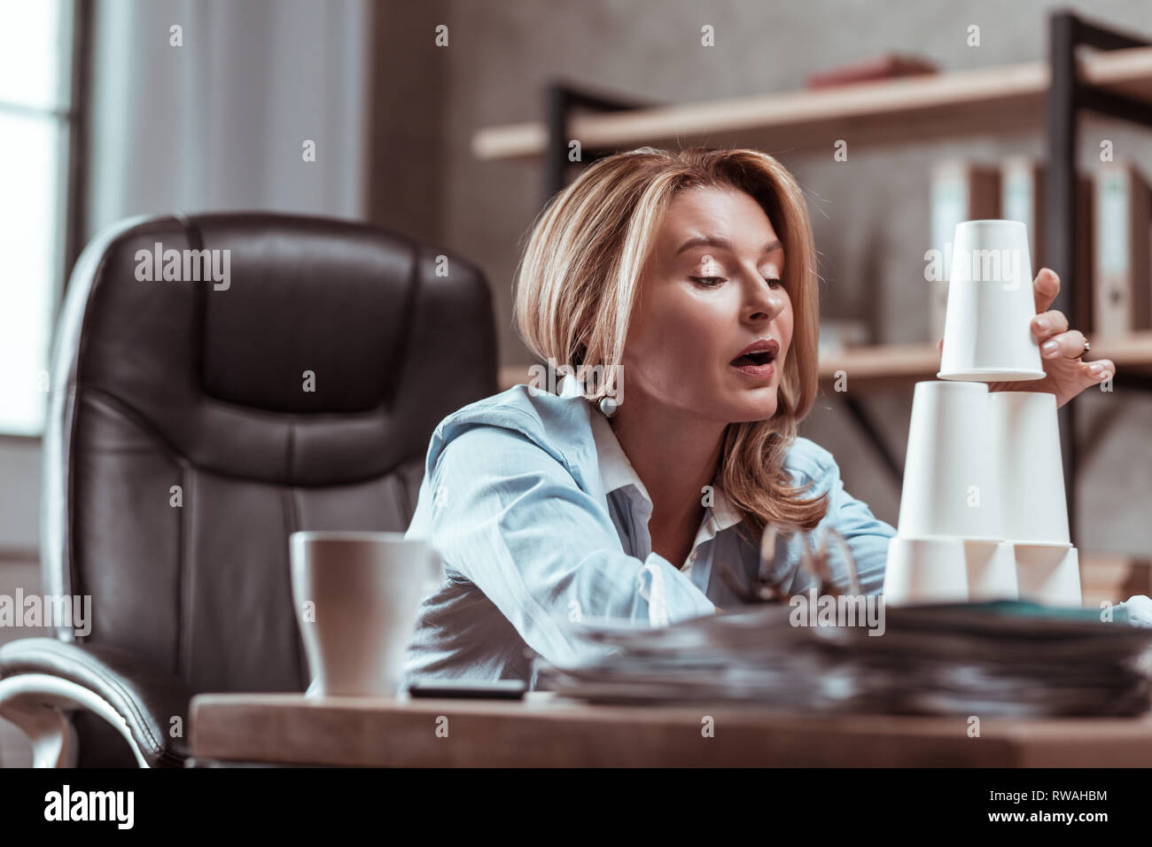 Woman feeling bored at work building pyramid from glasses Stock Photo ...