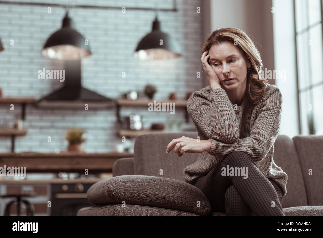 Blonde woman wearing grey sweater feeling sick and depressed Stock ...
