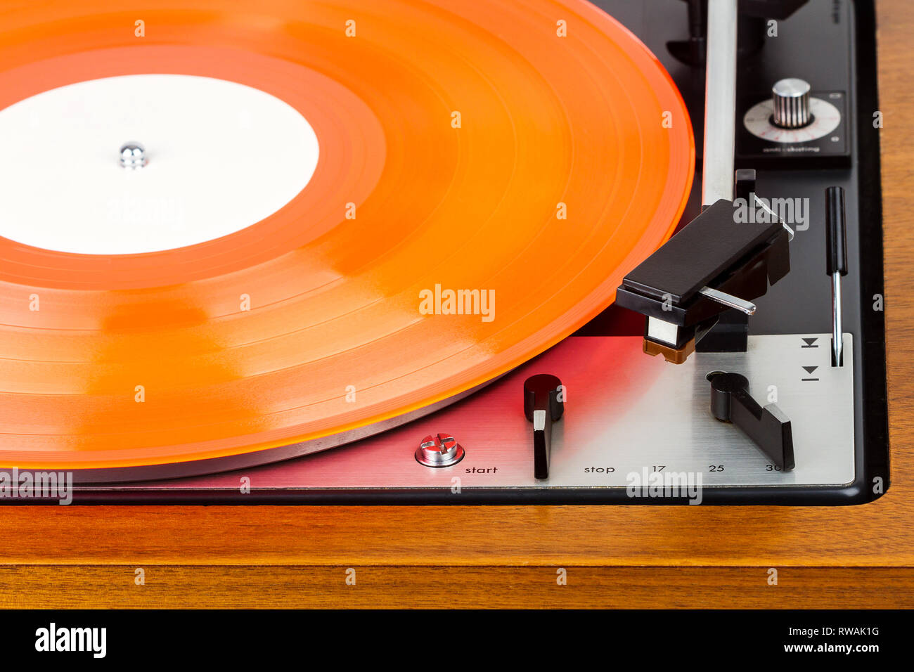 Close up of vintage turntable record player with red vinyl. Wooden ...