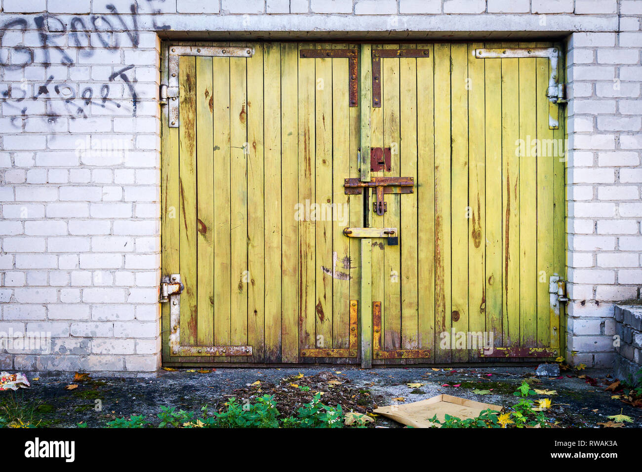 Old wooden gate in white brick wall. Architecture detail background ...
