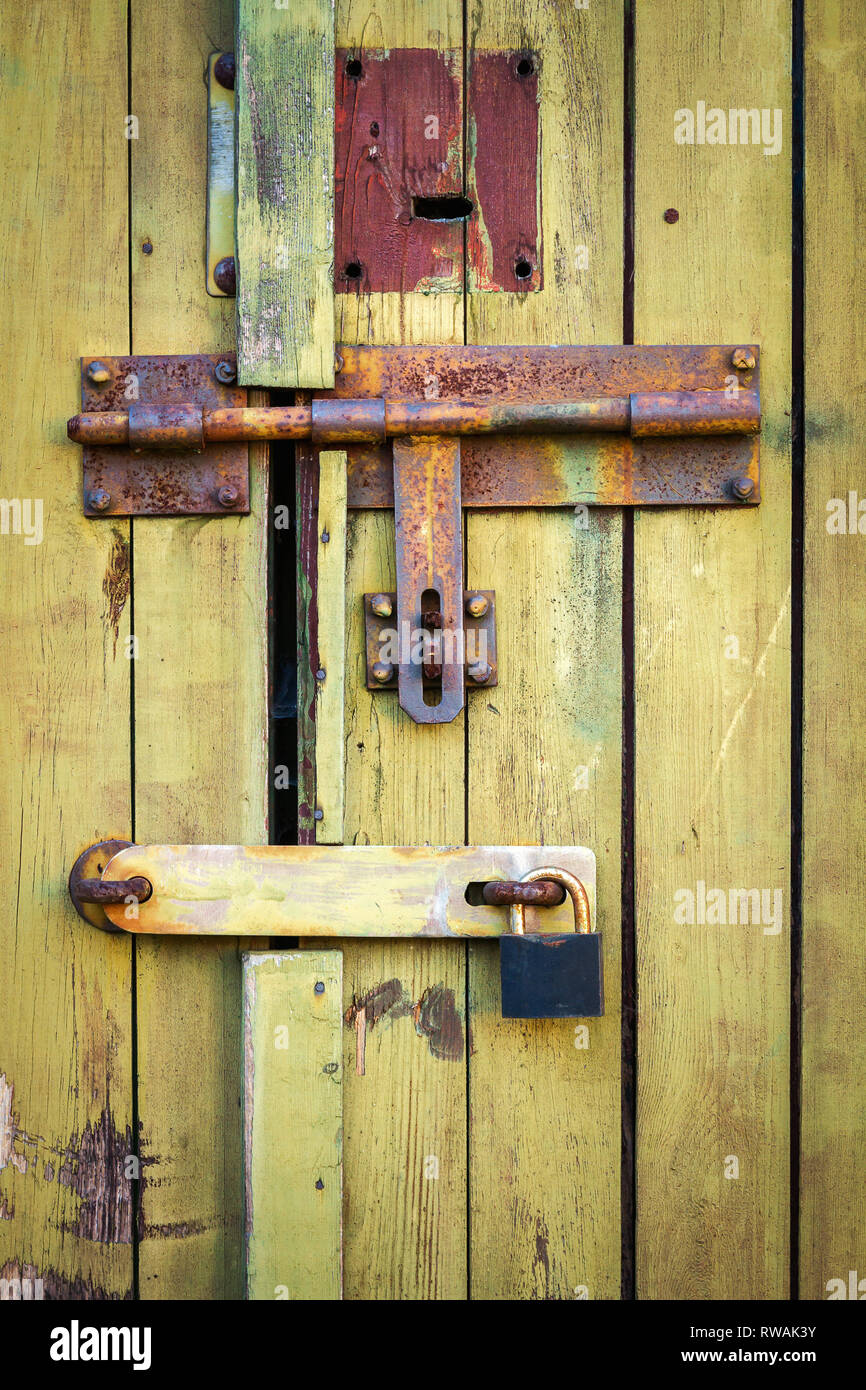 Old yellow wooden plank door with padlock. Architecture detail ...