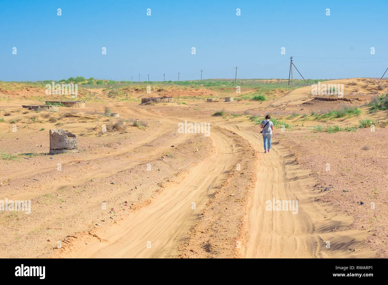 Photographer walking on a sandy trail outdoors in the countryside back ...