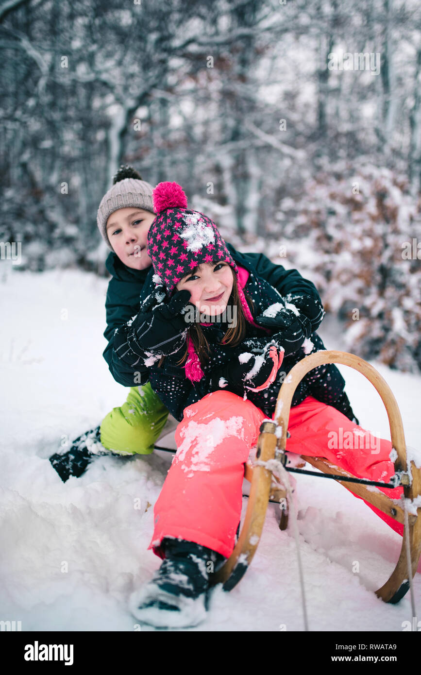 Two kids having fun on snow Stock Photo - Alamy