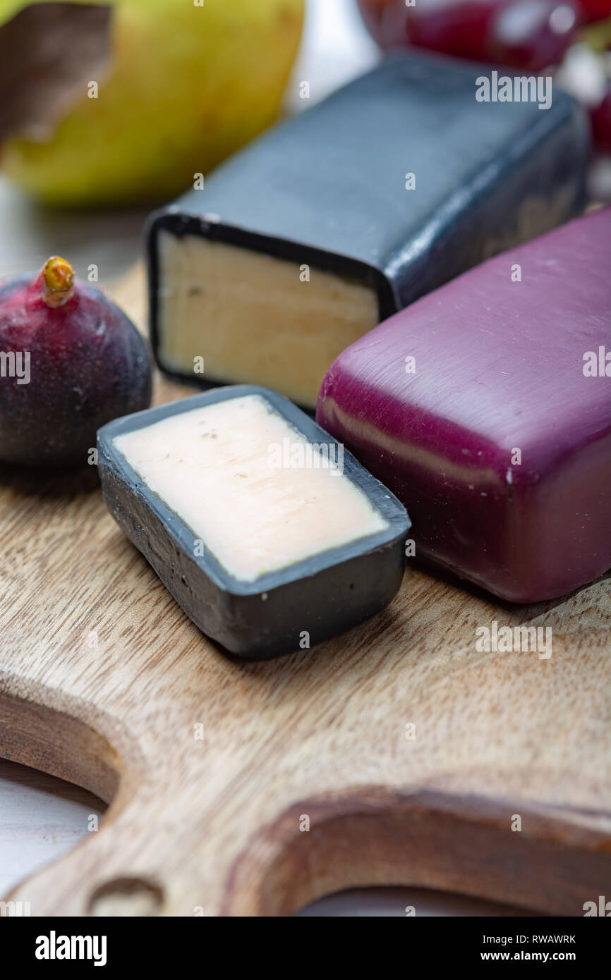 Mini black and dark red waxed cheddar cheeses made from West Country ...