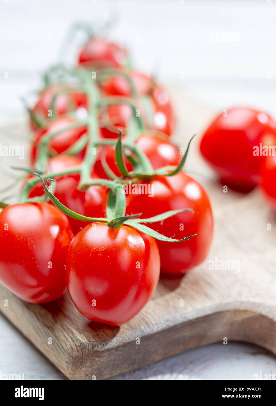 Vine of fresh ripe red cherry prunella tomates close up Stock Photo - Alamy
