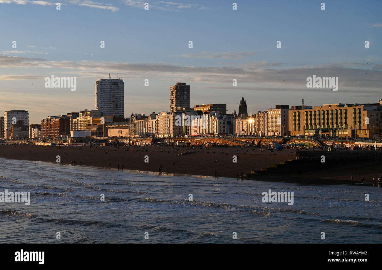 View of Brighton seafront and beach at sunset with sun shining on ...
