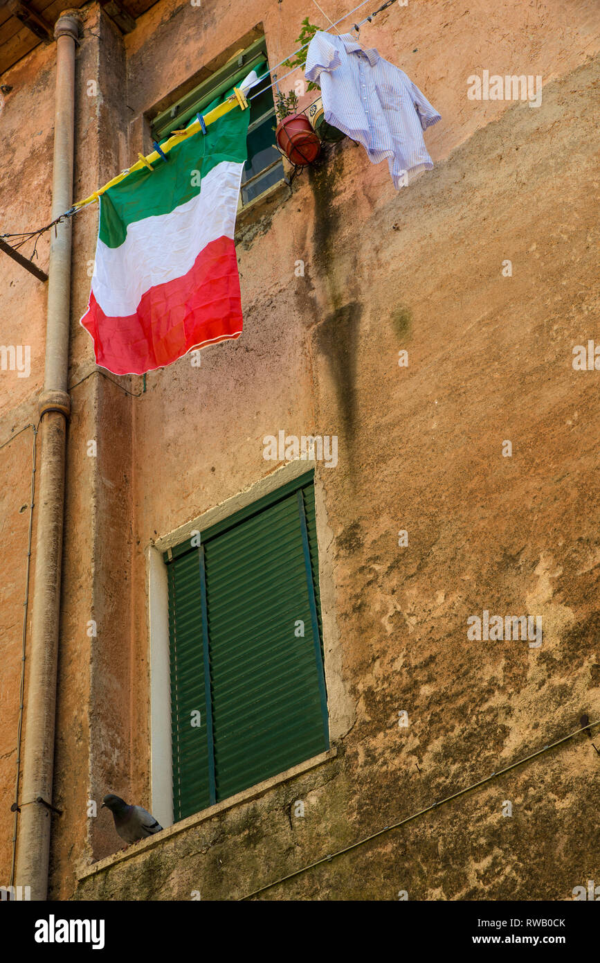 Hanging laundry at the laundry line in front of the window in Italy. An ...
