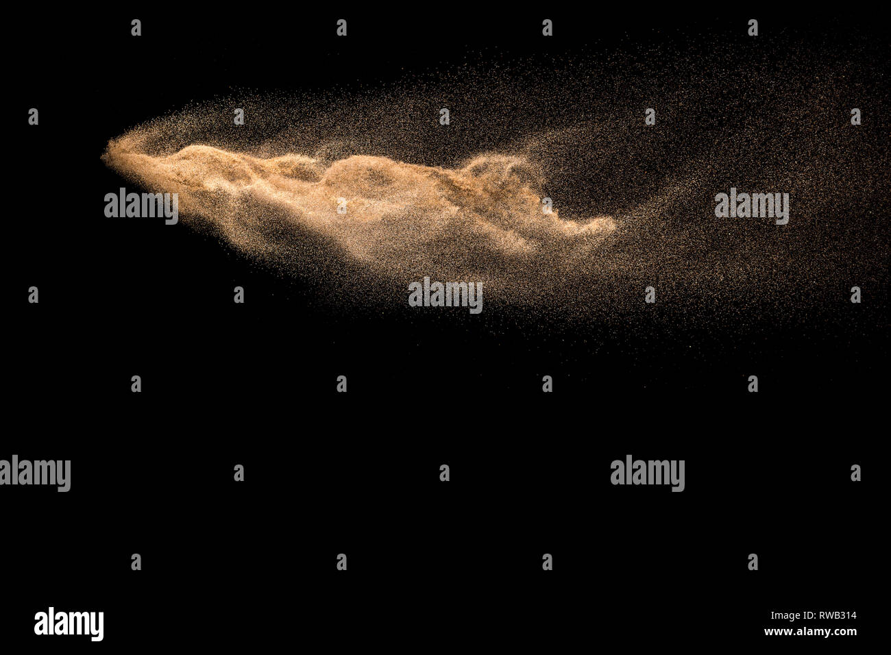 Golden sand explosion isolated on black background. Abstract sand cloud ...