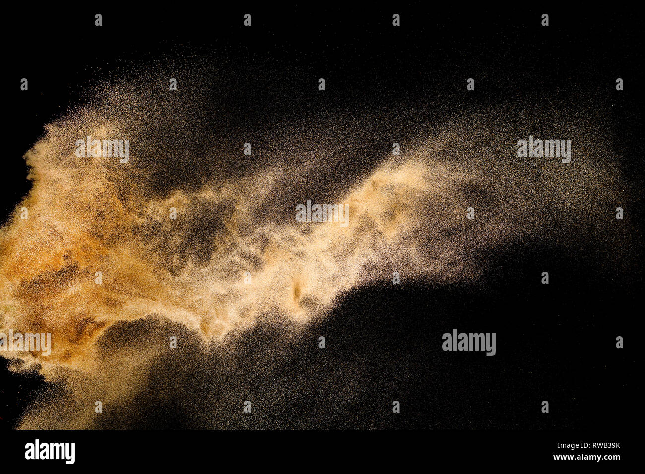 Golden sand explosion isolated on black background. Abstract sand cloud ...