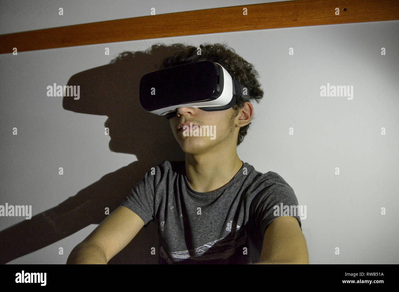 A young Caucasian boy wears the VR 360 viewer in his room, the virtual ...