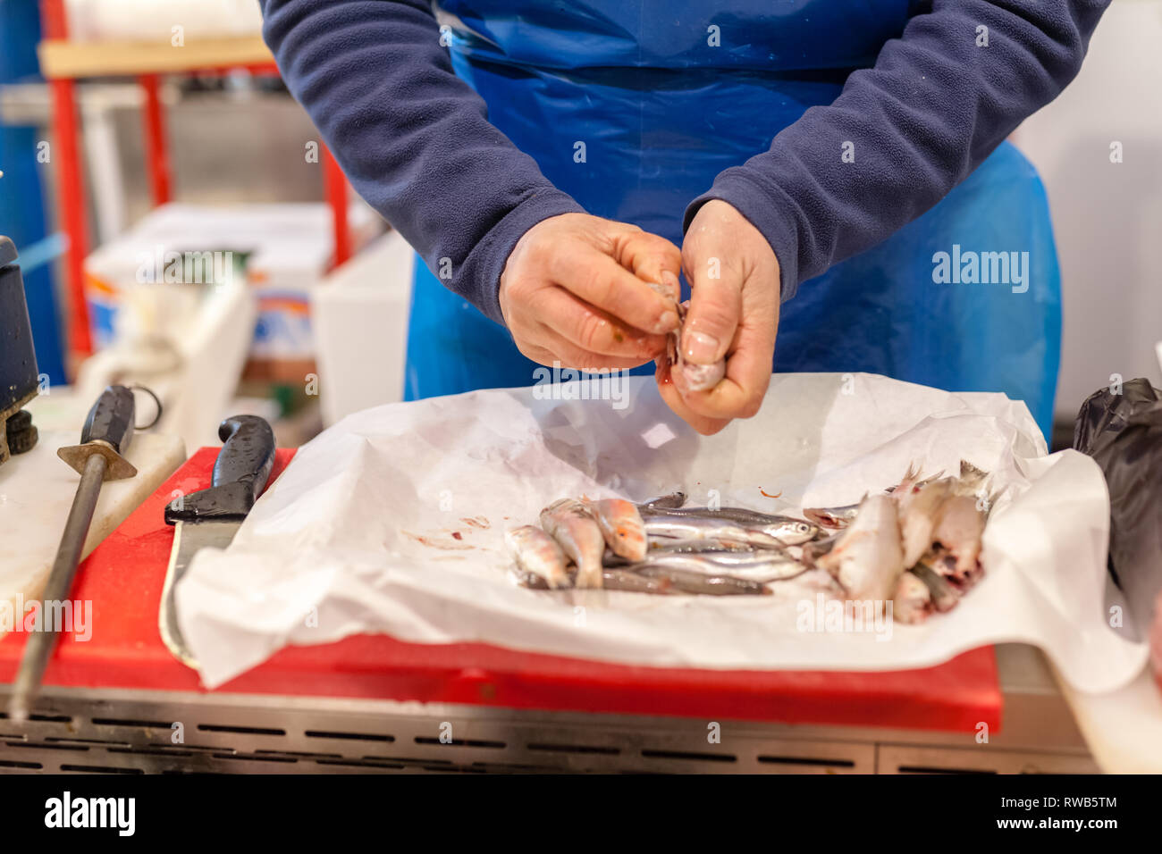 vendor cutting fish. A typical scene at the traditional fish market ...