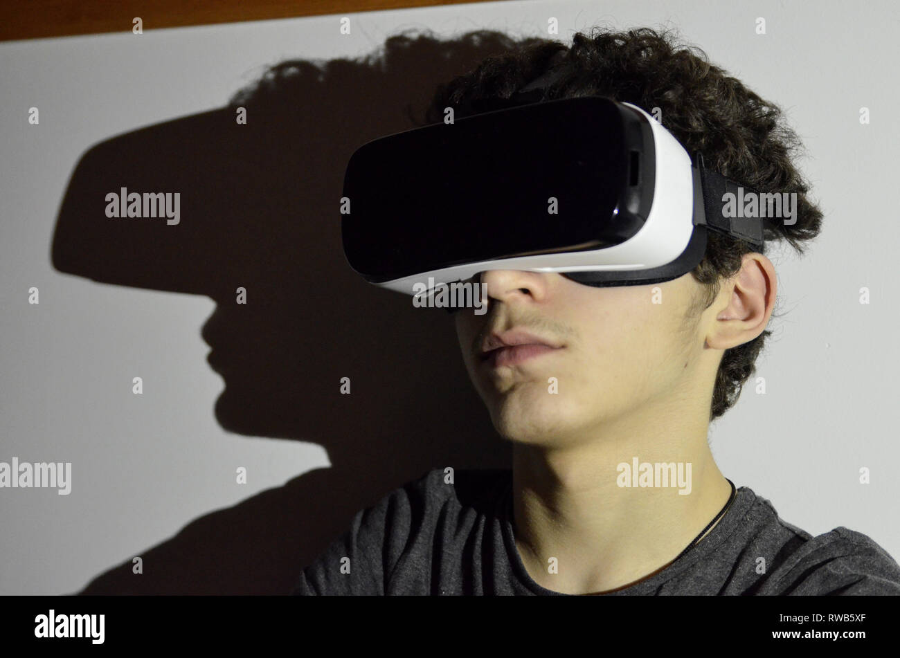 A young Caucasian boy wears the VR 360 viewer in his room, the virtual ...