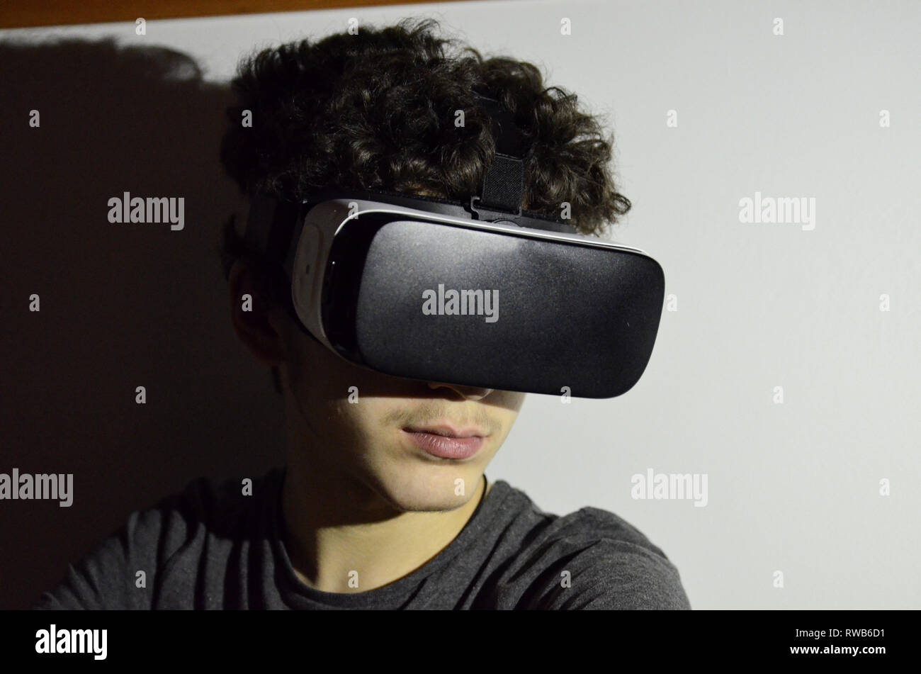 A young Caucasian boy wears the VR 360 viewer in his room, the virtual ...