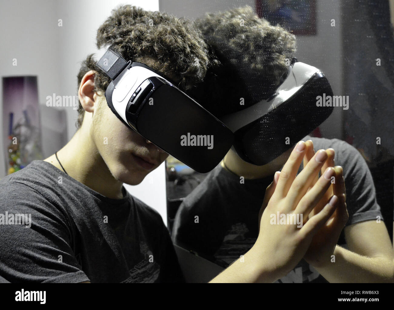 A young Caucasian boy wears the VR 360 viewer in his room, the virtual ...