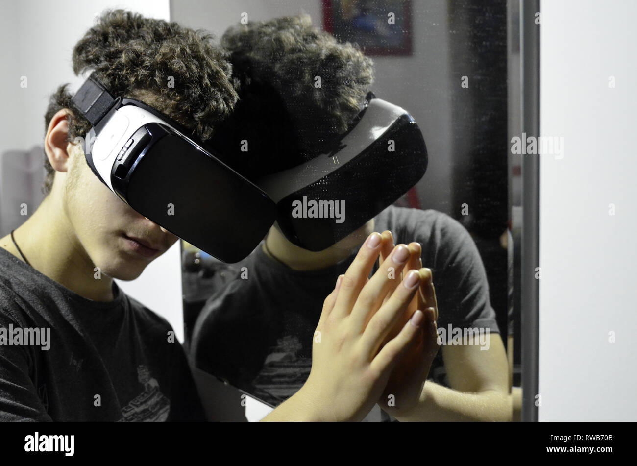 A young Caucasian boy wears the VR 360 viewer in his room, the virtual ...