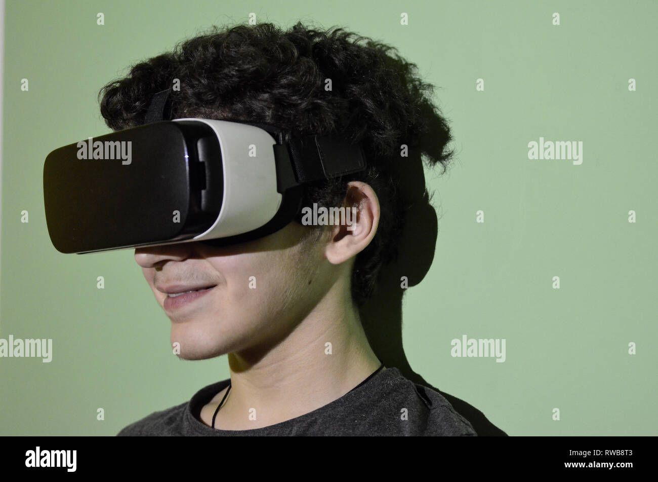A young Caucasian boy wears the VR 360 viewer in his room, the virtual ...