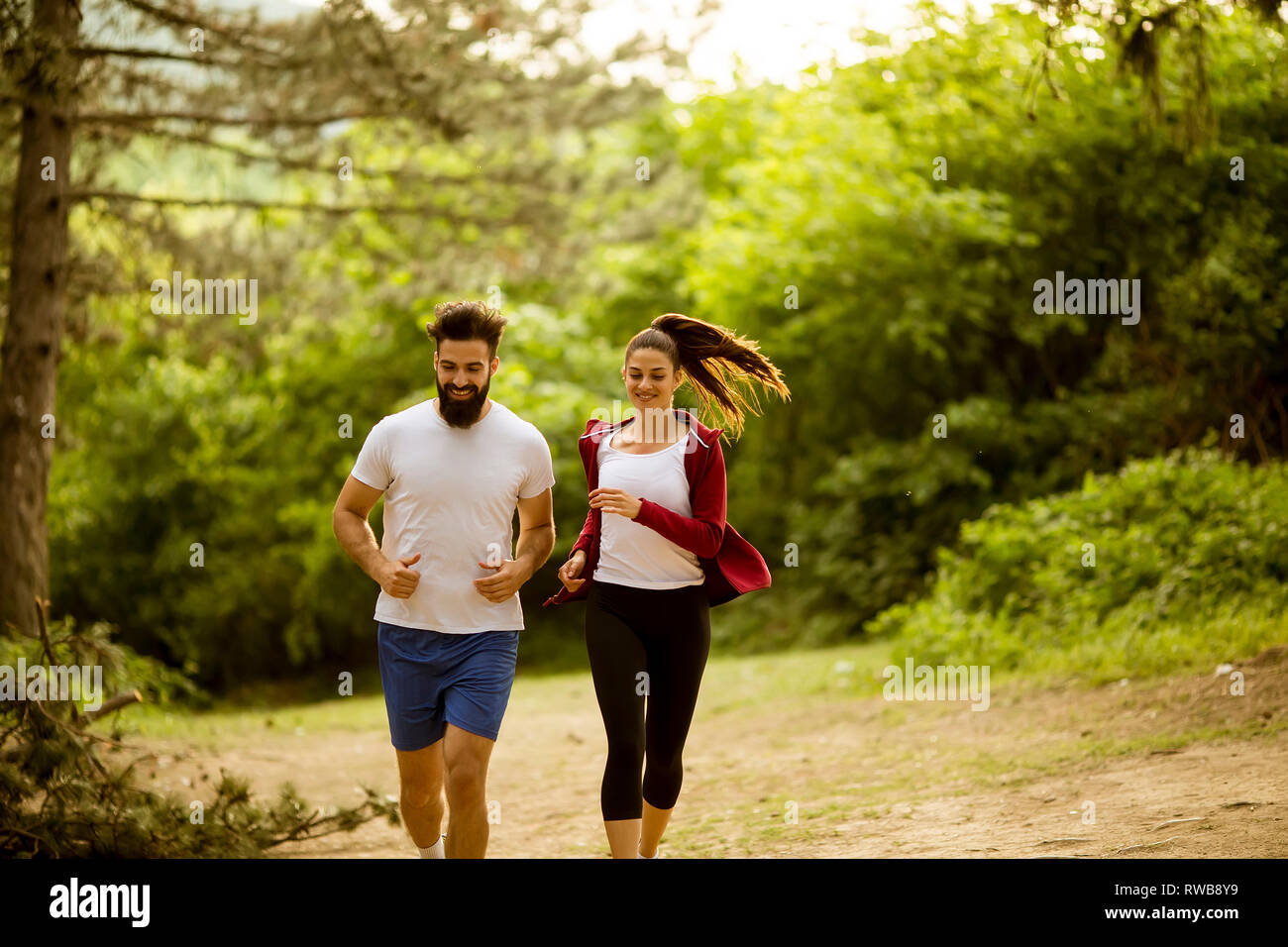 Healthy fit and sportive couple running in nature at summer day Stock ...