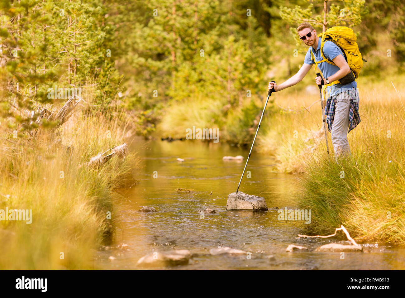 Young man crosses river hi-res stock photography and images - Alamy