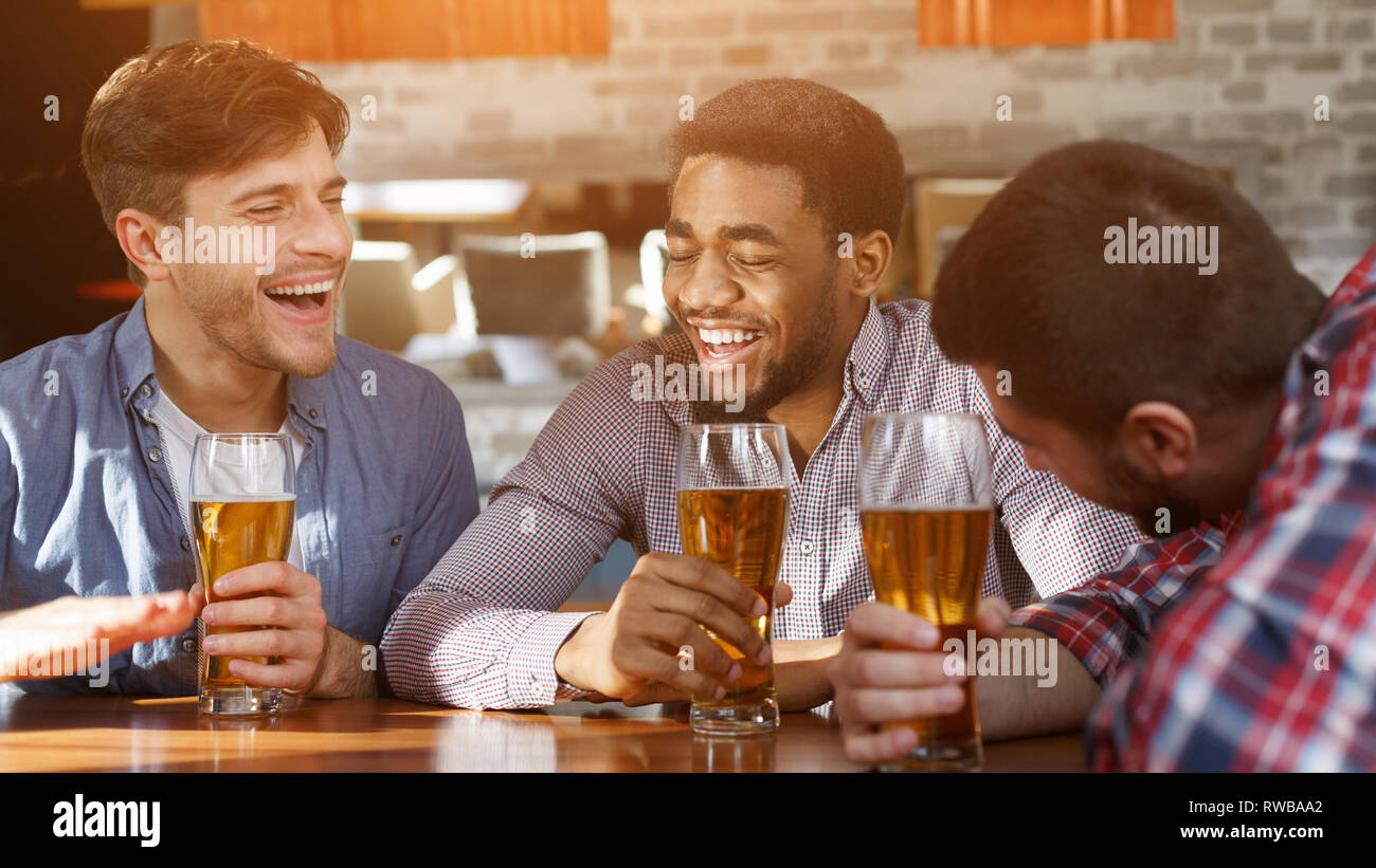 Best friends having fun and drinking beer at bar counter Stock Photo ...