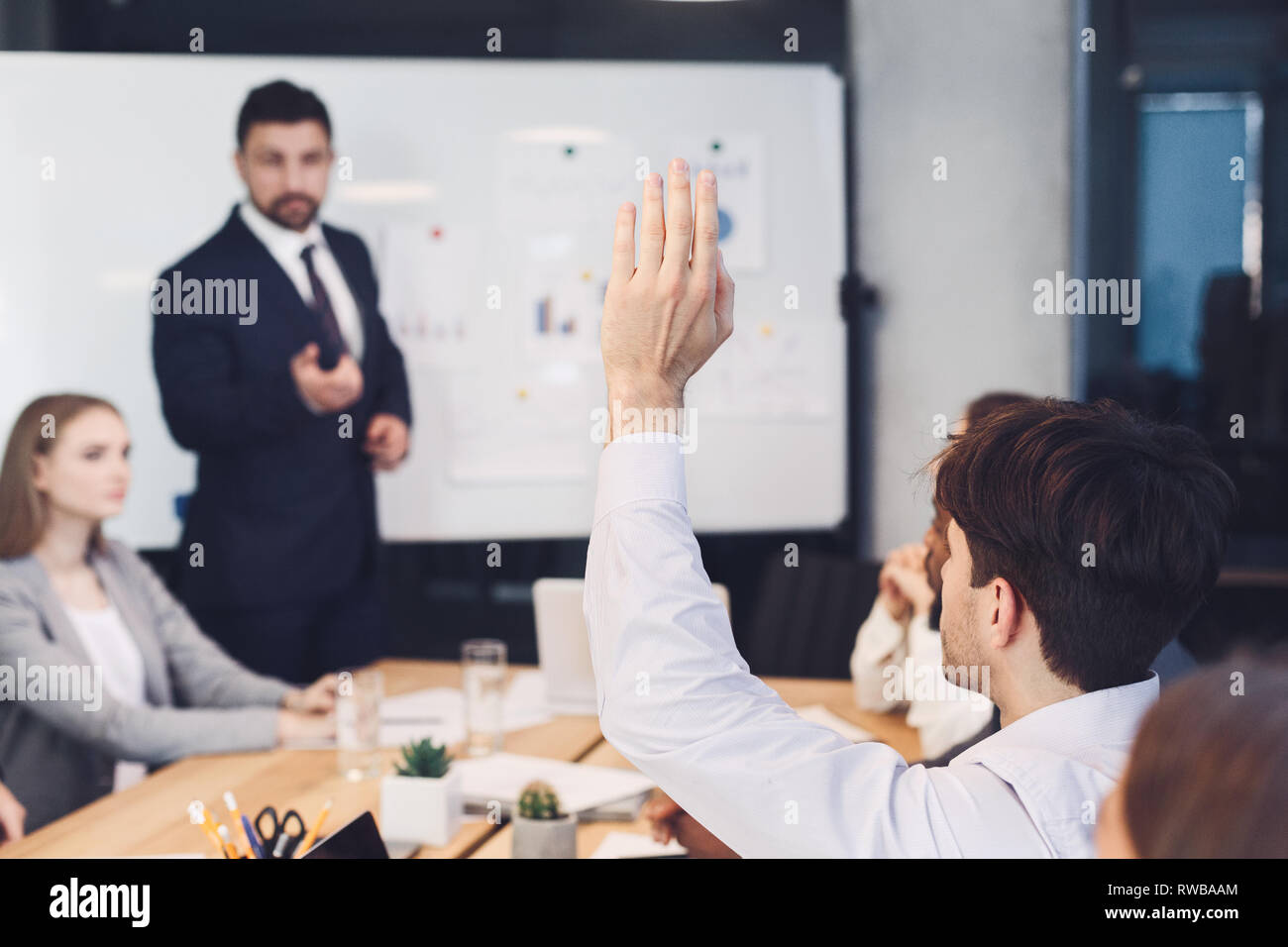 Businessman asking question to speaker at presentation Stock Photo - Alamy
