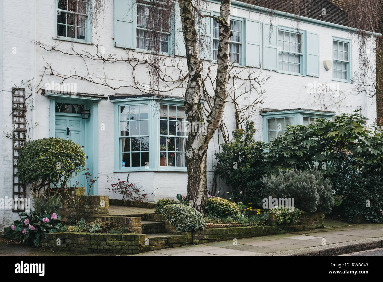 Colourful turquoise door and trim on a facade of traditional English ...