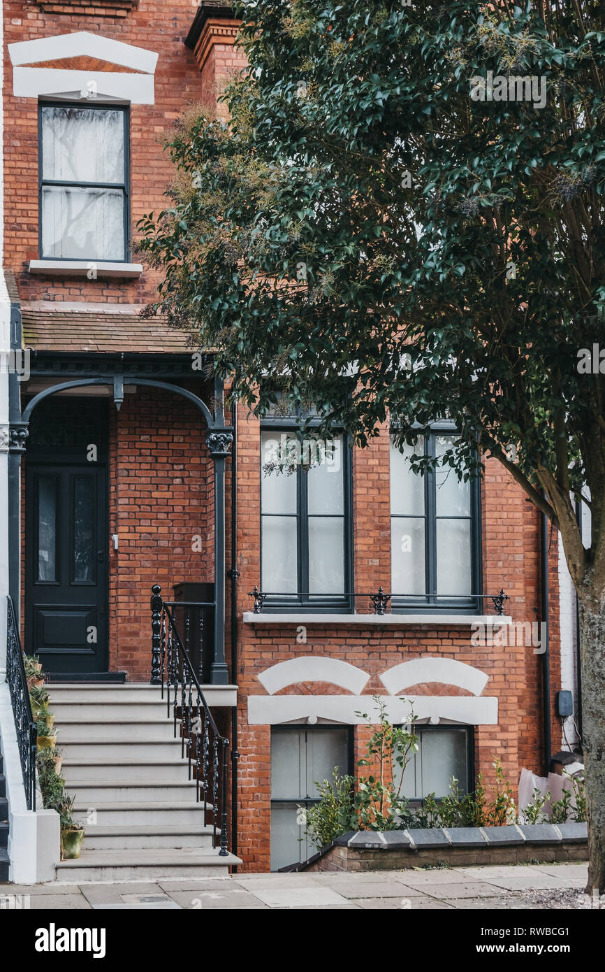 Black front door on a facade of traditional English house in London, UK ...