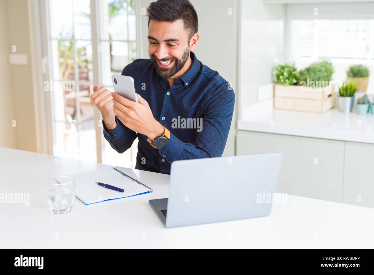 Handsome hispanic business man using smartphone and laptop at the ... Handsome hispanic business man using smartphone and laptop at the ...