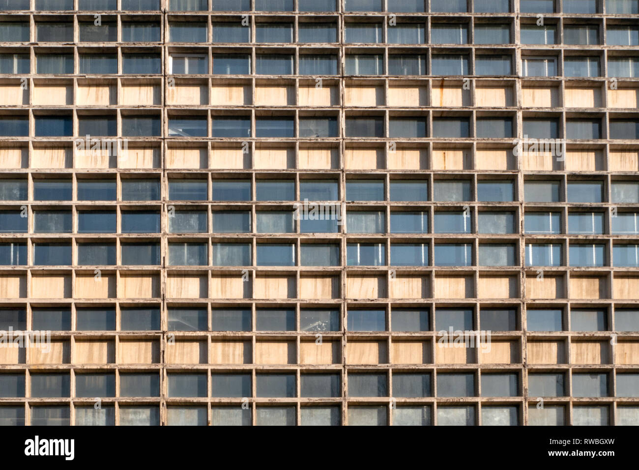 Facade of skyscraper. Many windows of geometric. Wall with lots of ...