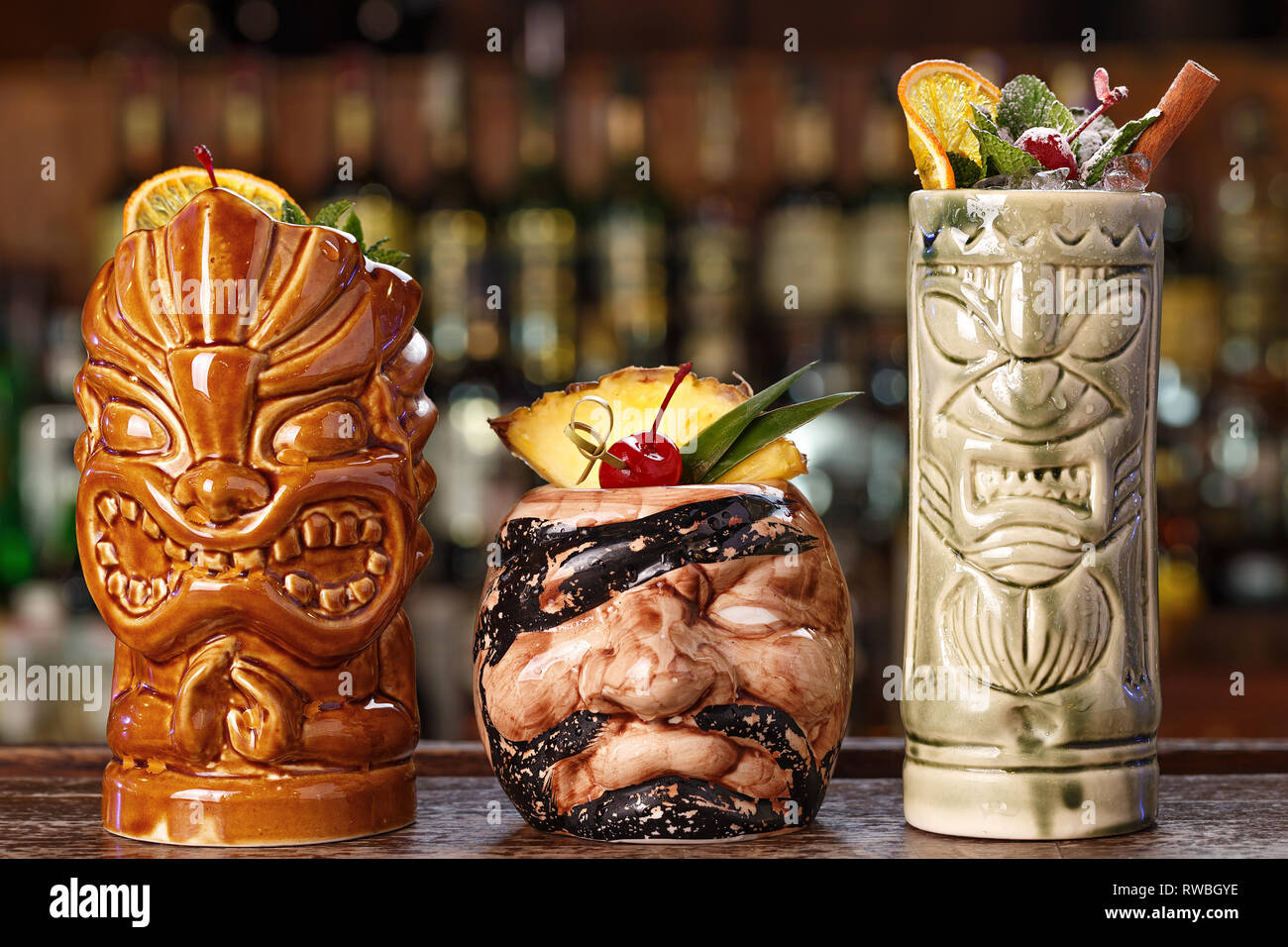 Set of three tropical cocktails in tiki glasses - pina colada, rum ...