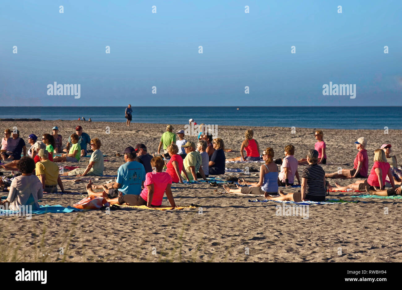 yoga class; adults; people; outdoors; sand beach; healthy, relaxation ...