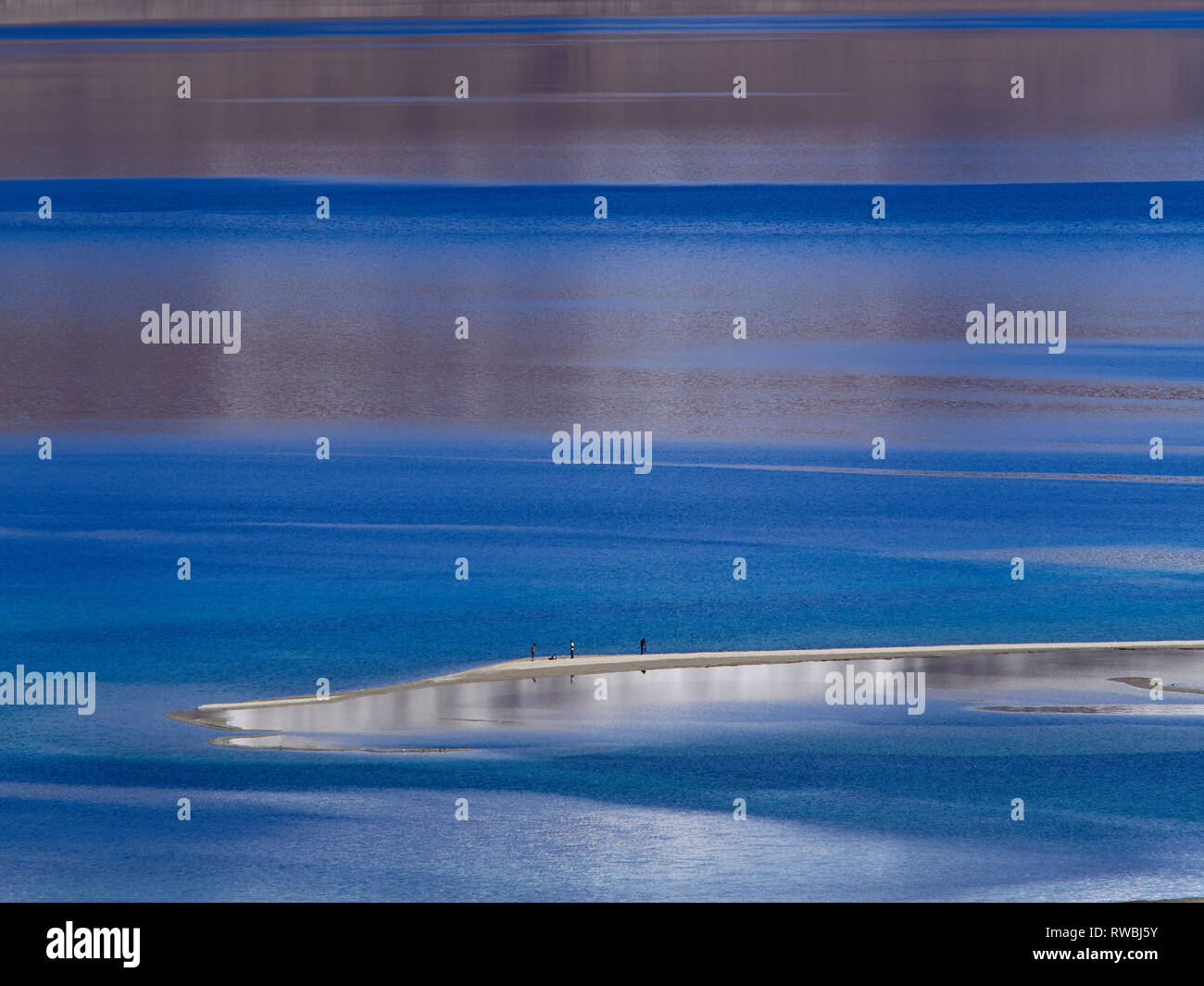 Lake Pangong, blue calm water with pink stripes, an island of sand on ...
