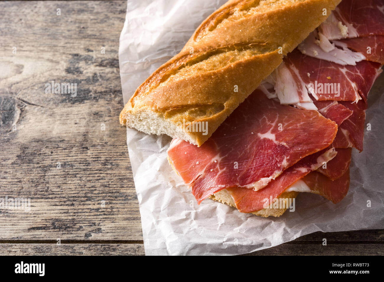 Spanish serrano ham sandwich on wooden table. Copyspace Stock Photo - Alamy