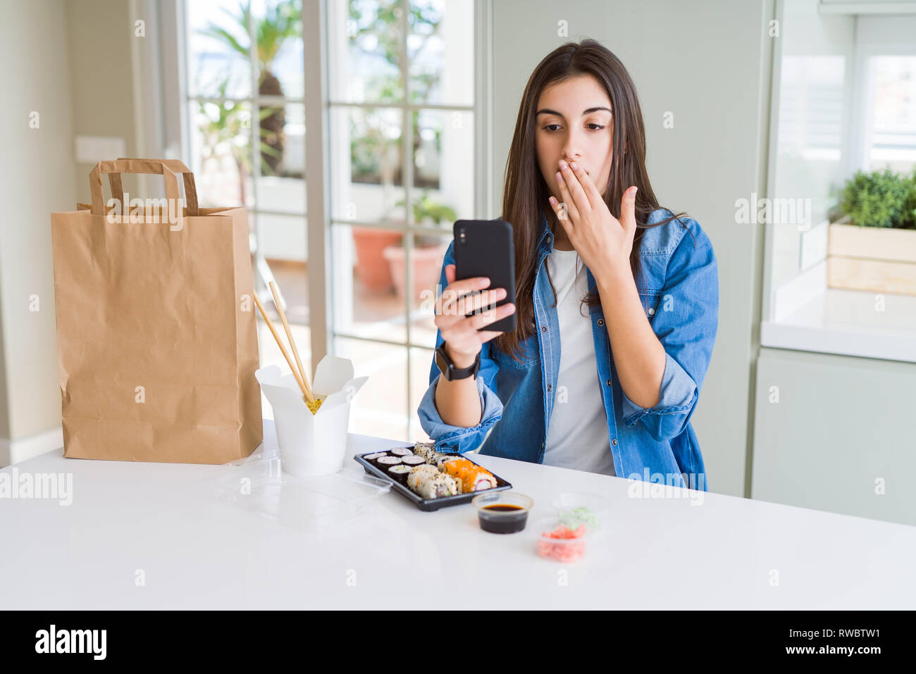 Beautiful young woman ordering food delivery from app using smartphone ...