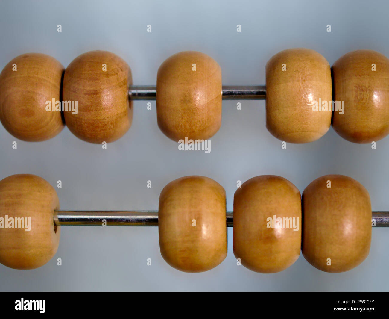 Two rows of natural wood abacus beads on cyan wall background Stock ...