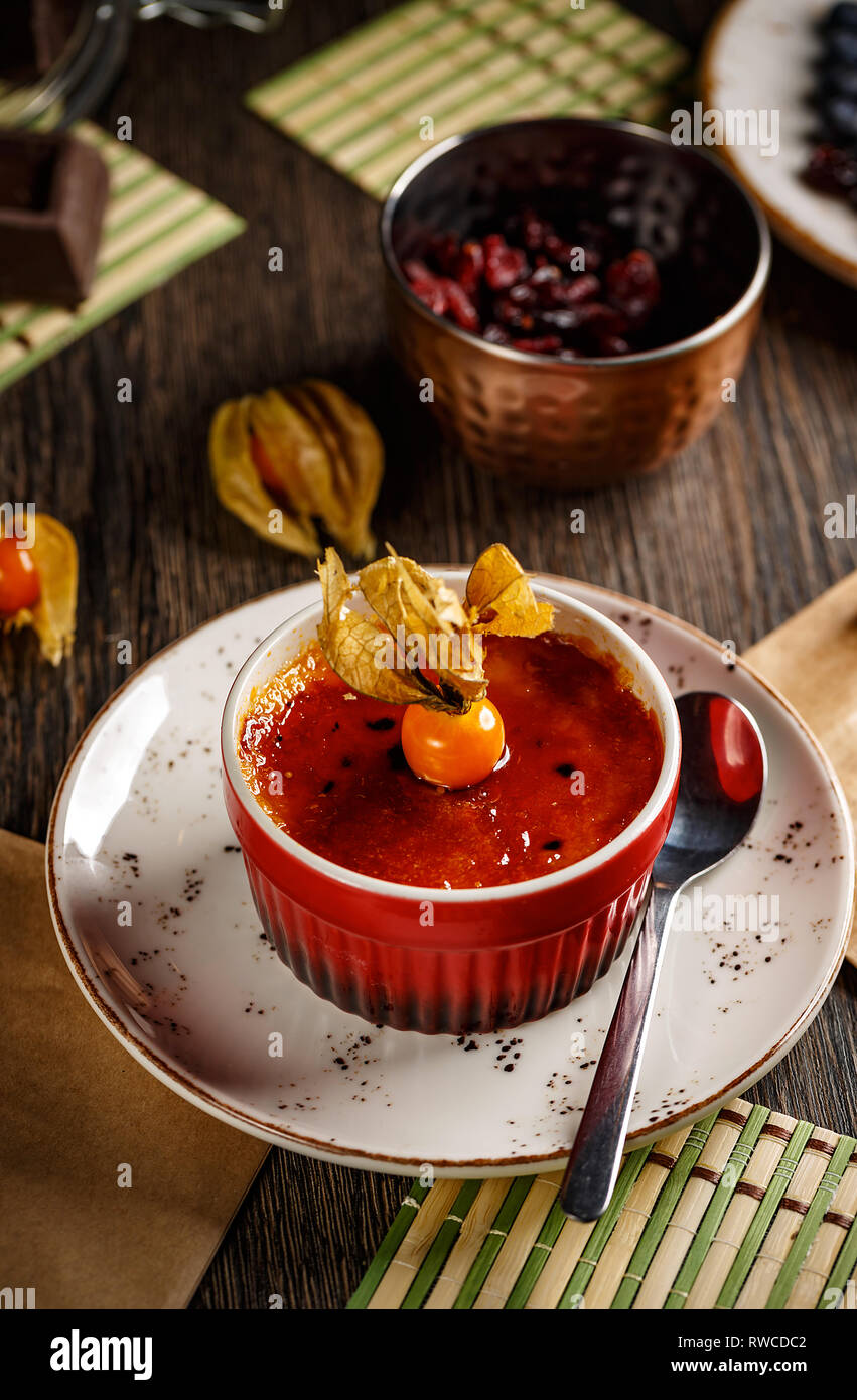 Tasty cream brulee in the bowl decorated with cape gooseberry Stock ...