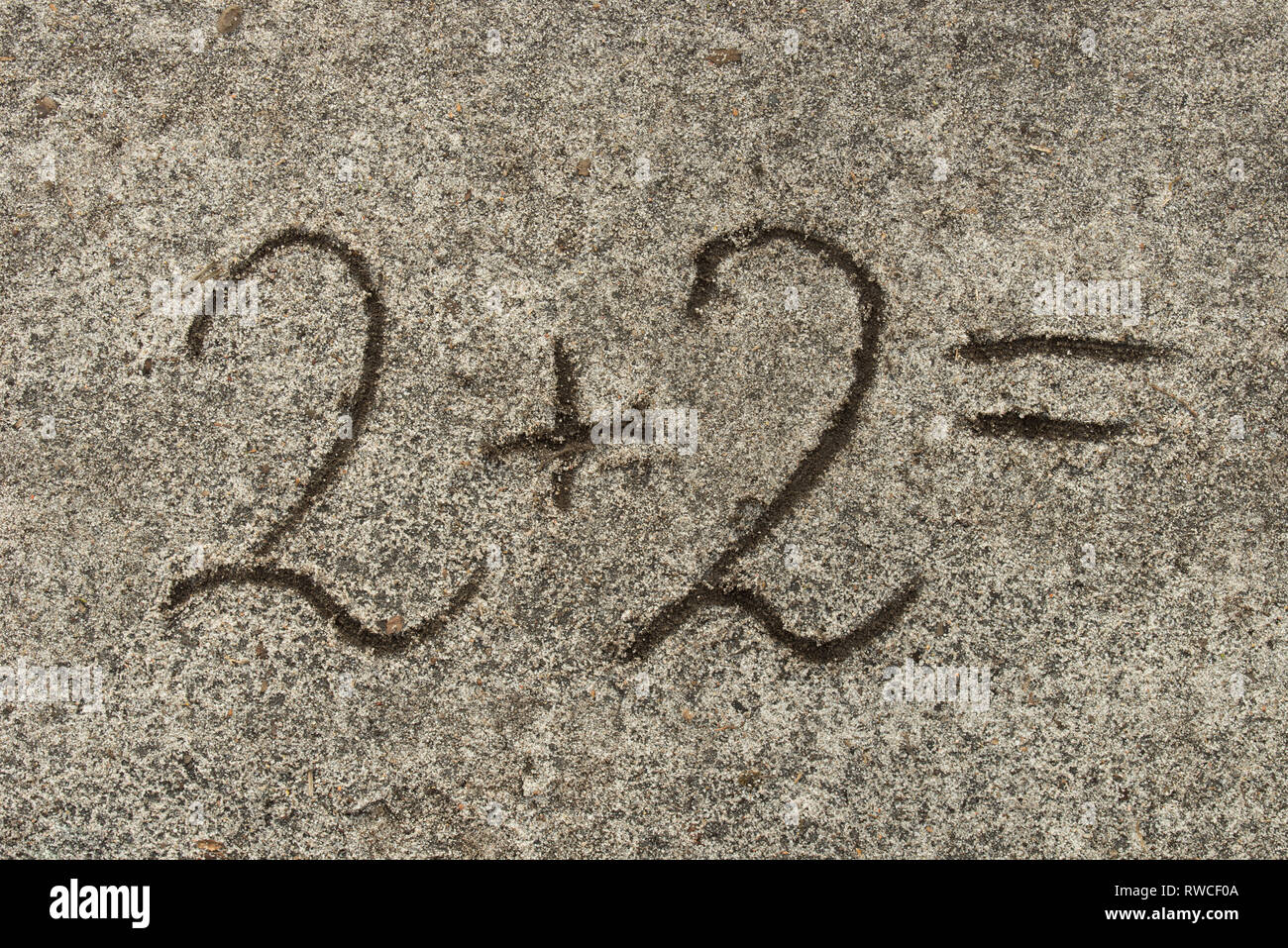 mathematical equation. two plus two on sand background Stock Photo - Alamy