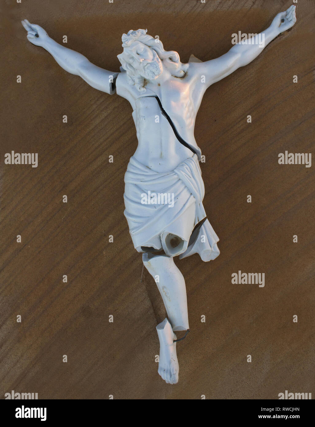 A marble statue depicting a crucified Jesus with arms outstretched ...