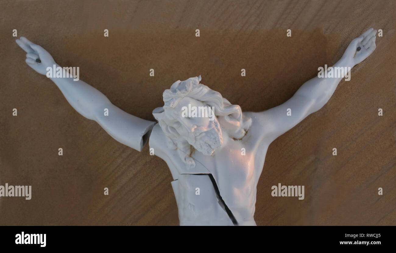 A marble statue depicting a crucified Jesus with arms outstretched ...