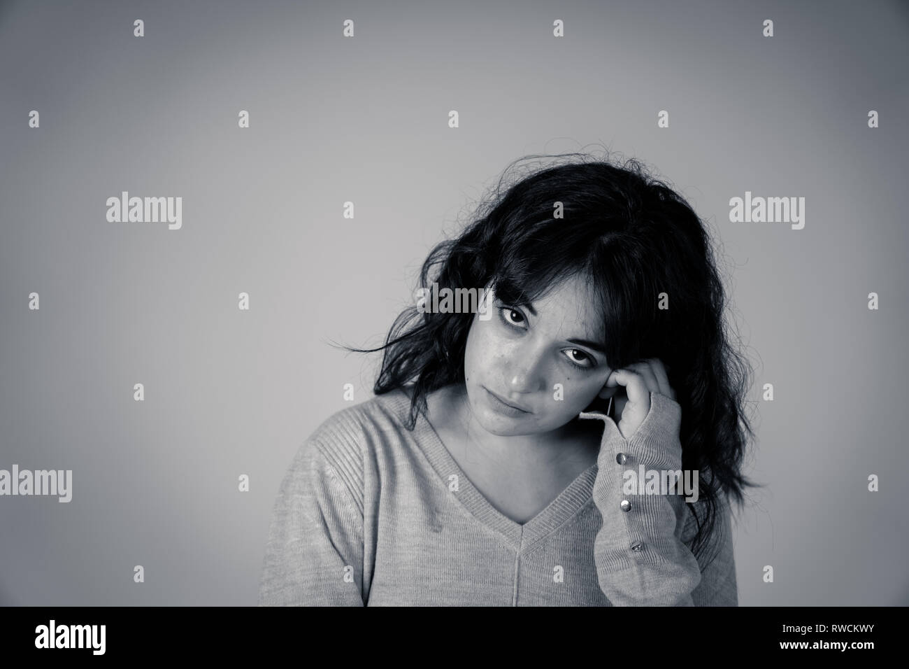 Close up portrait of beautiful young woman with sad eyes looking desperate and melancholy. Human ...