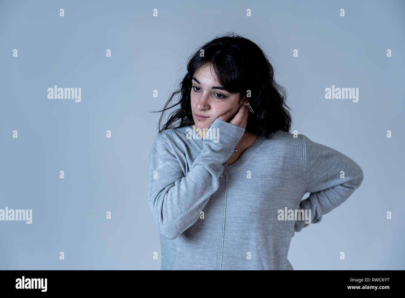 Close up portrait of beautiful young woman with sad eyes looking desperate and melancholy. Human ...