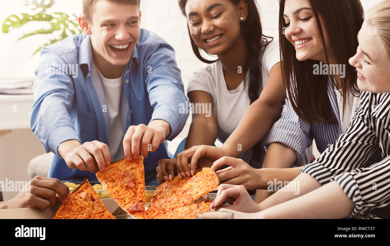 Happy friends eating pizza, spending time together Stock Photo - Alamy