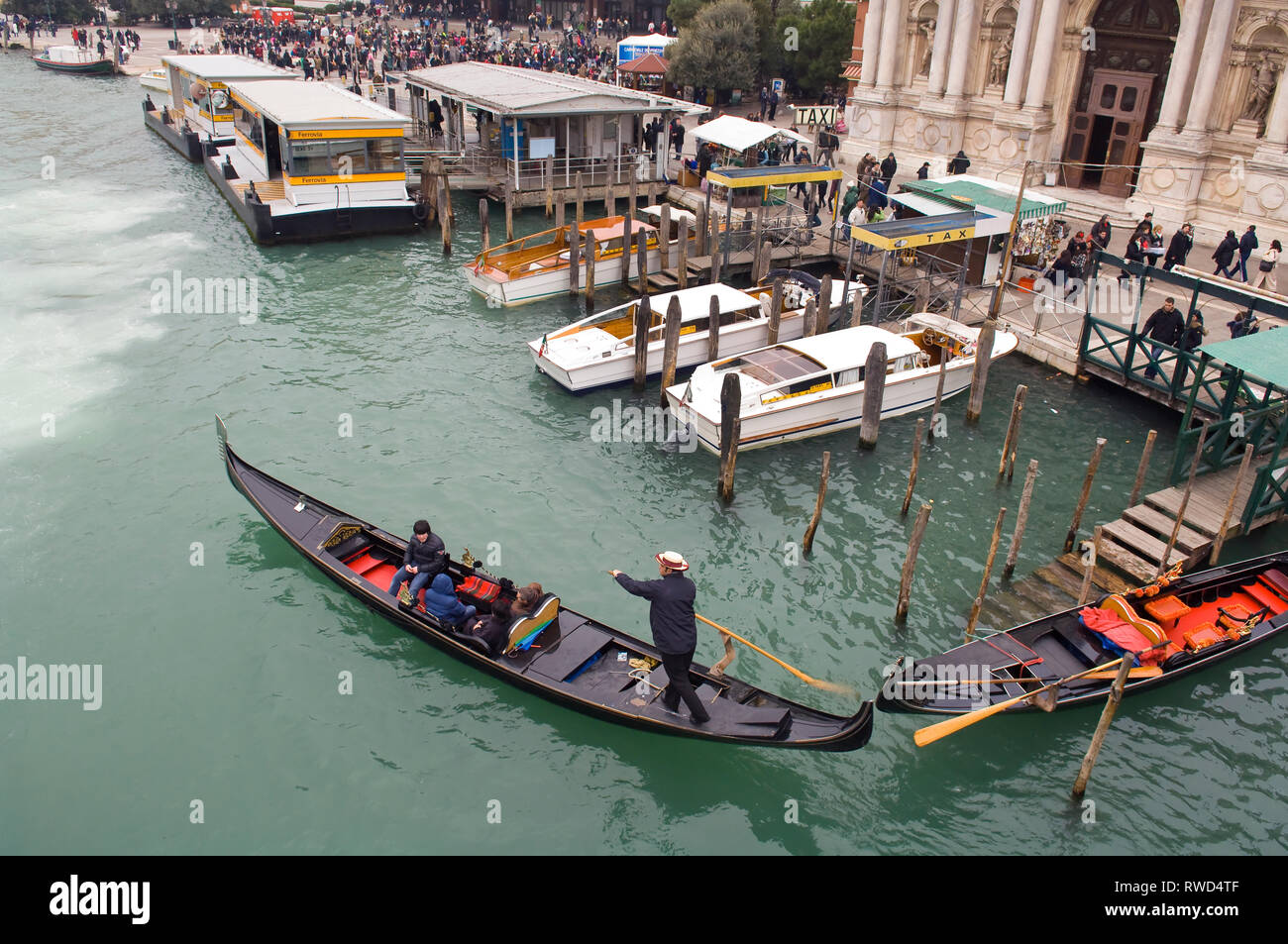 A Gondolier steering a Gondola among other boats including the river ...
